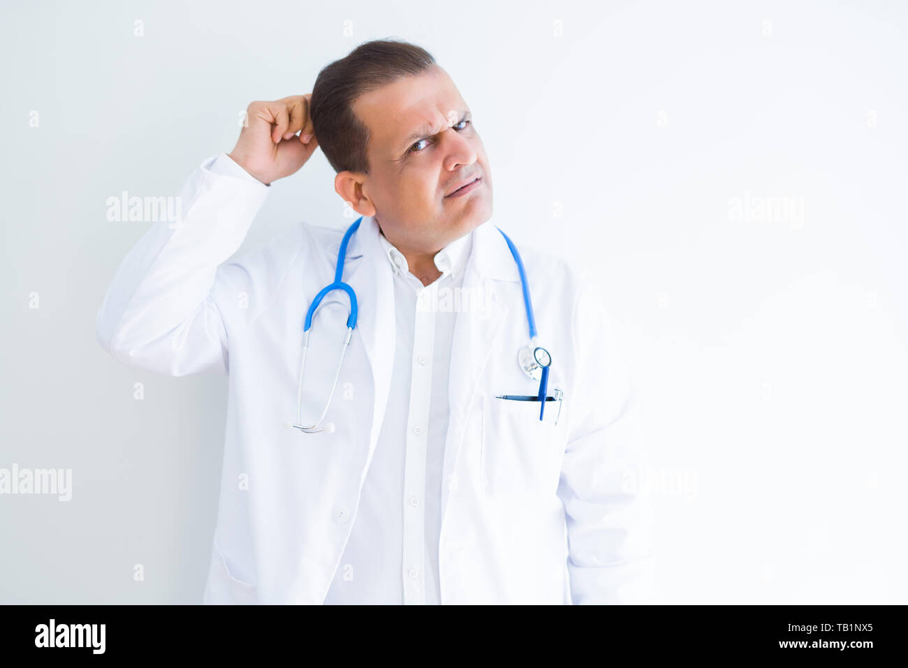 Middle age doctor man wearing stethoscope and medical coat over white ...