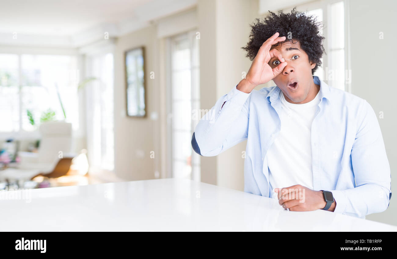 African American man at home doing ok gesture shocked with surprised ...
