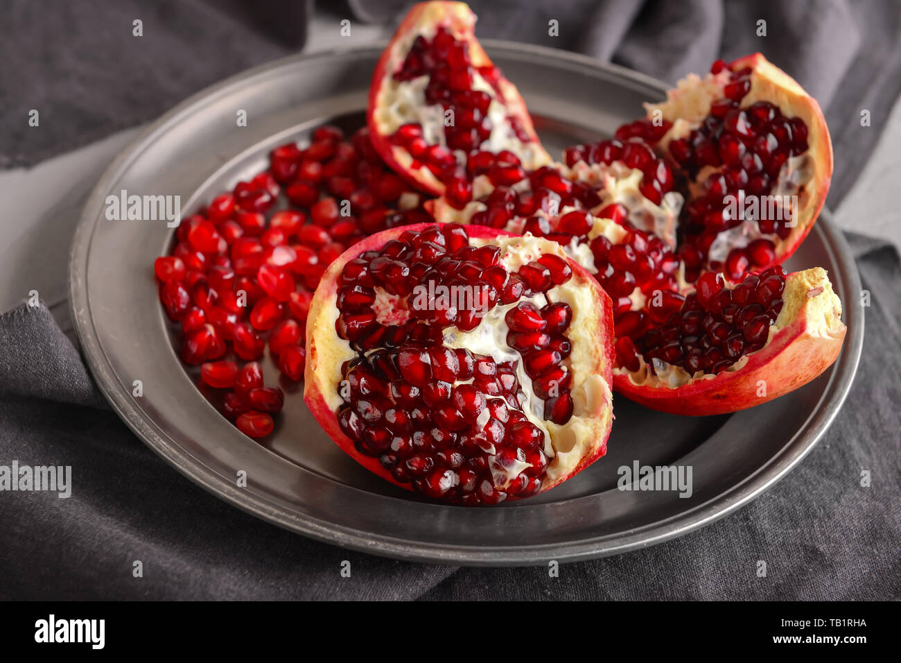 Plate with ripe pomegranate on table Stock Photo - Alamy