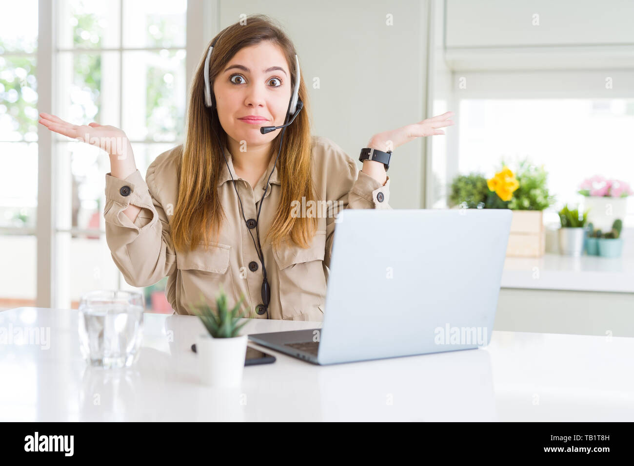Beautiful young operator woman working with laptop and wearing headseat ...