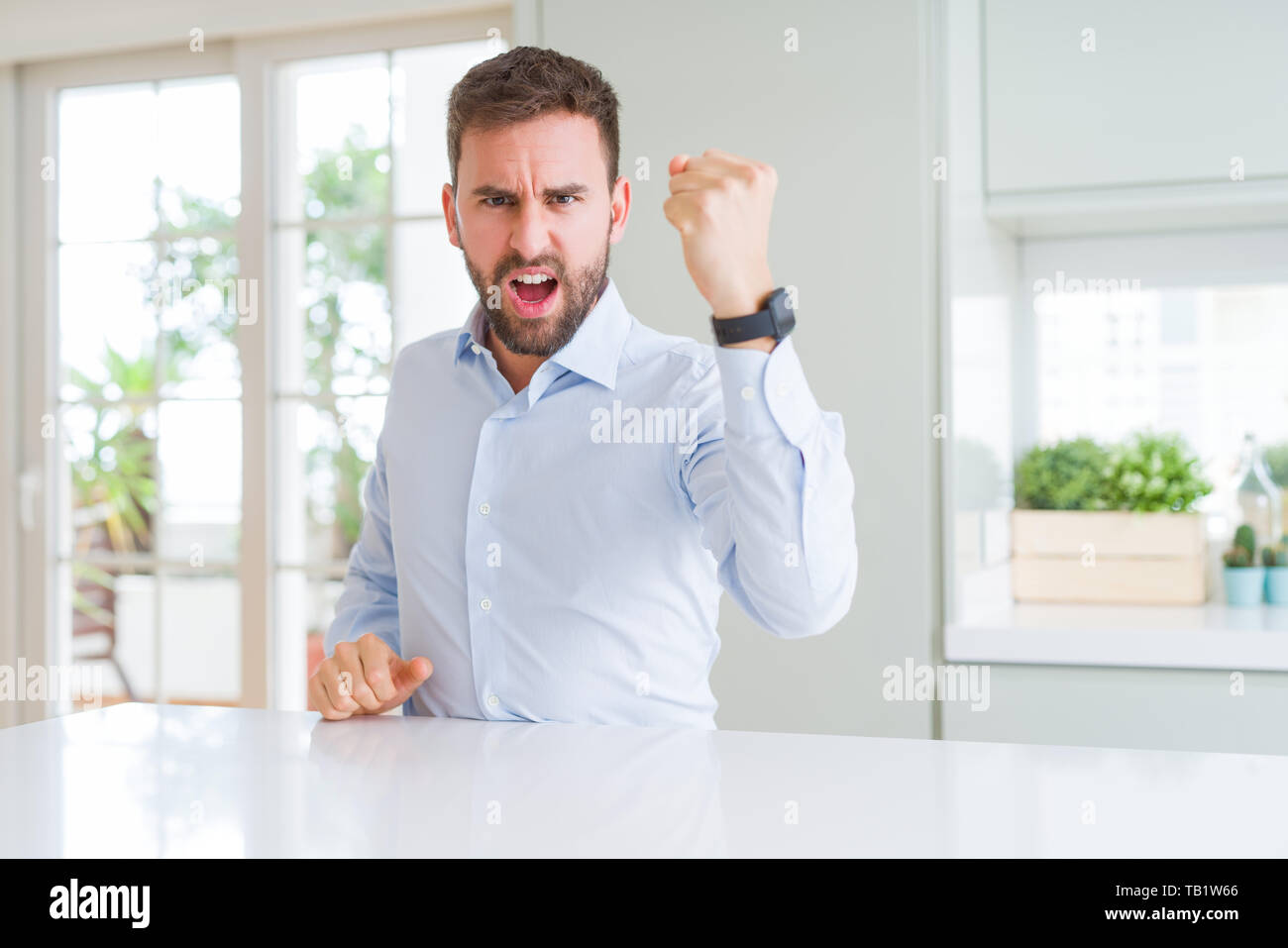 Handsome business man angry and mad raising fist frustrated and furious ...