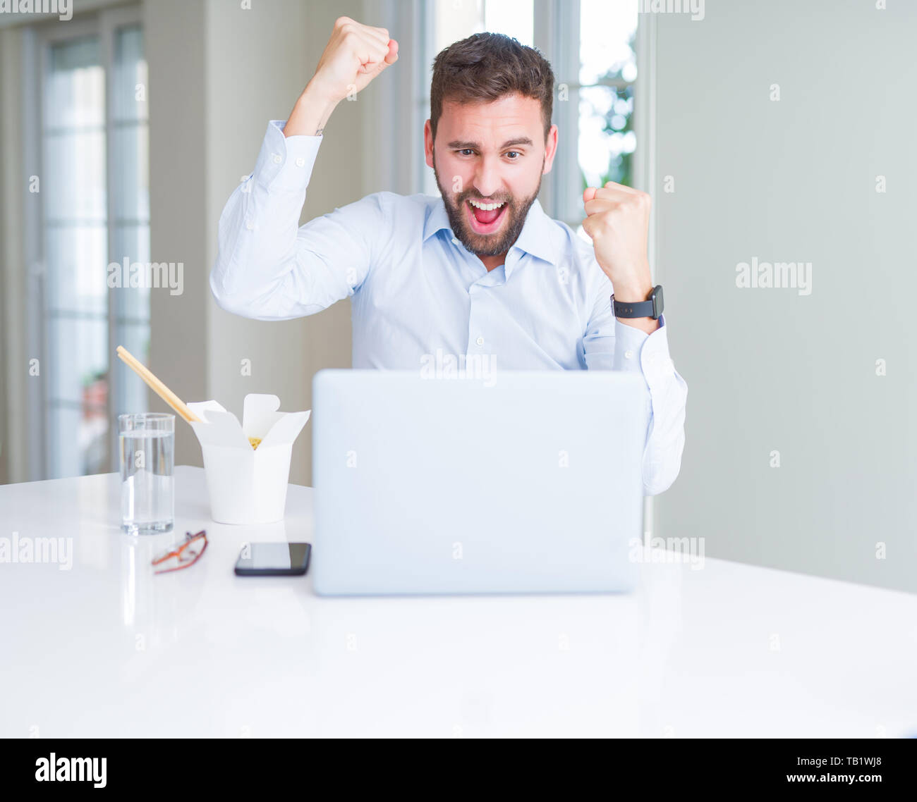Business man eating take away asian noodles food while working using ...
