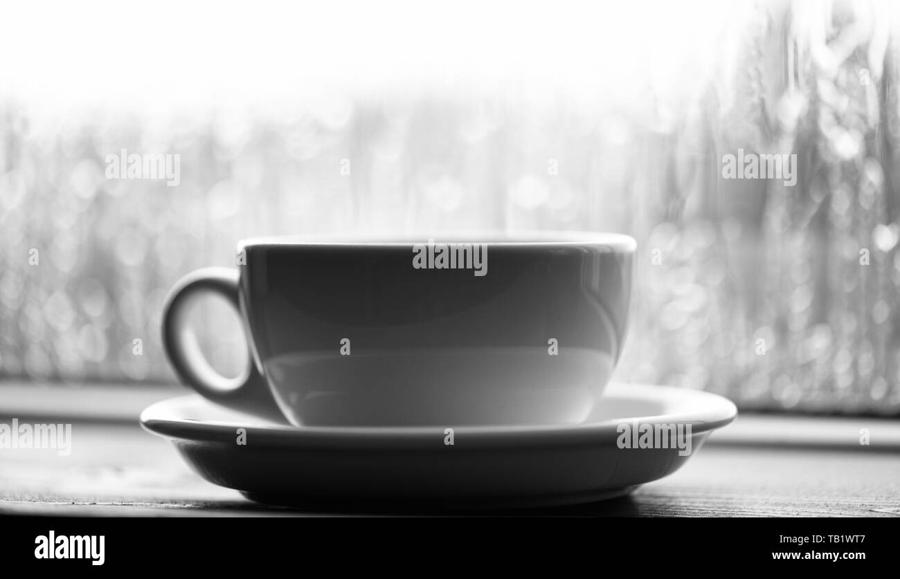 Coffee time on rainy day. Wet glass window and cup of hot coffee ...