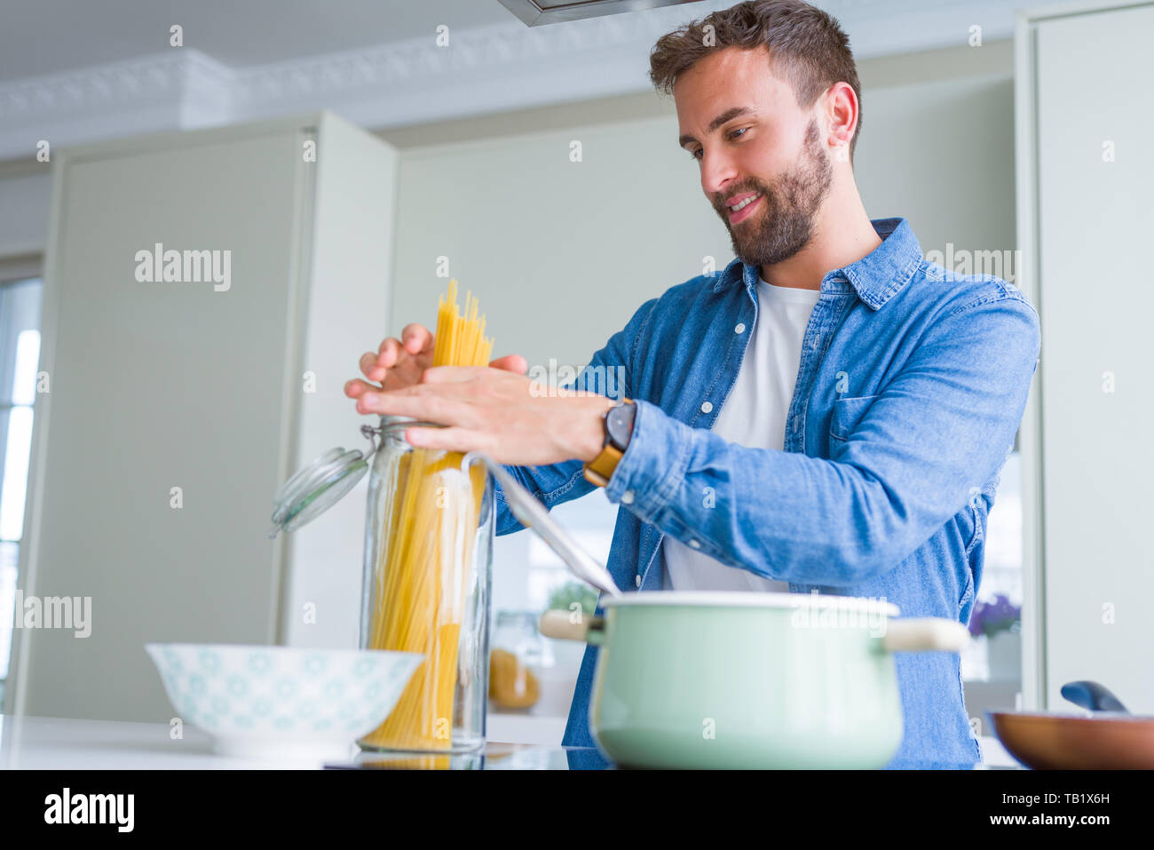 Handsome man cooking pasta at home Stock Photo - Alamy