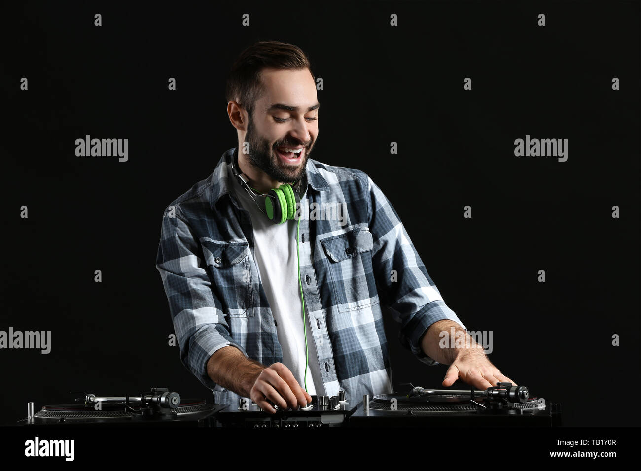 Male DJ playing music on dark background Stock Photo - Alamy