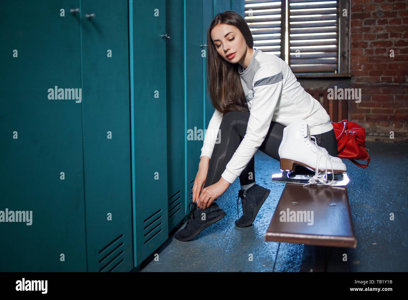 Girl skater with figure skates. Young woman in the locker room, skater ...