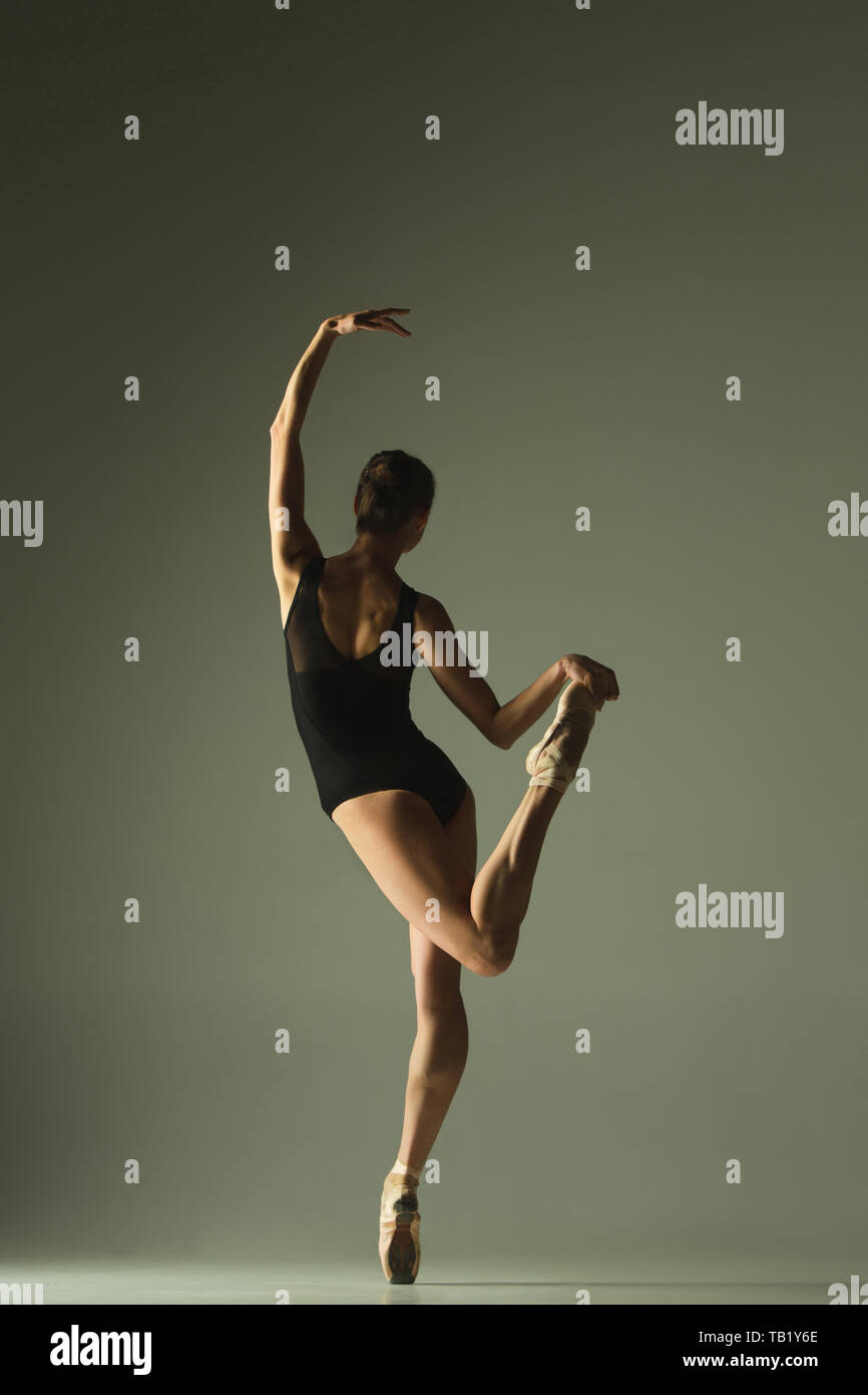 Graceful ballet dancer or classic ballerina dancing isolated on grey ...