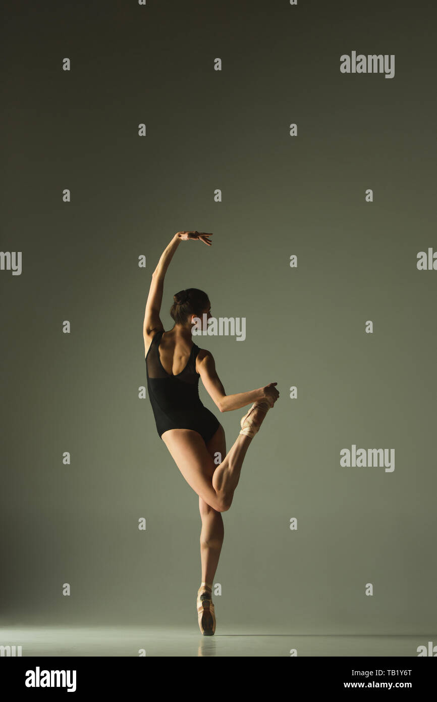 Graceful ballet dancer or classic ballerina dancing isolated on grey ...