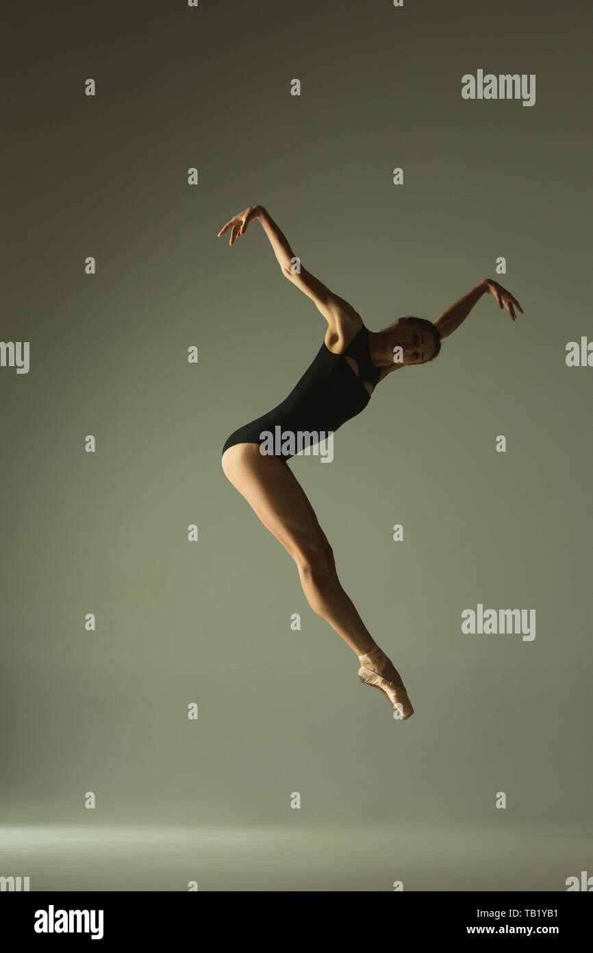 Graceful ballet dancer or classic ballerina dancing isolated on grey ...