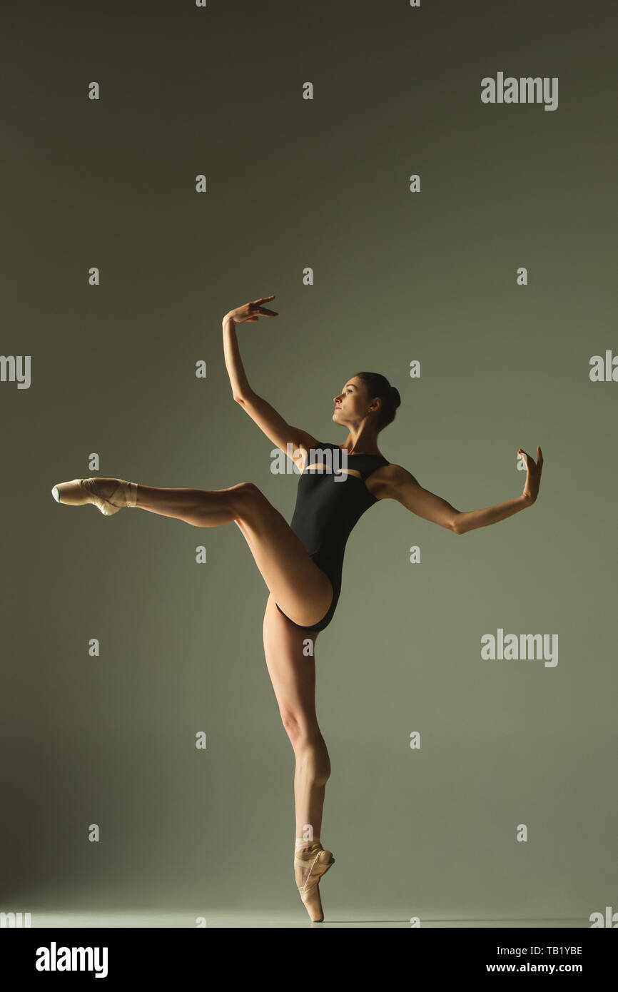 Graceful ballet dancer or classic ballerina dancing isolated on grey ...