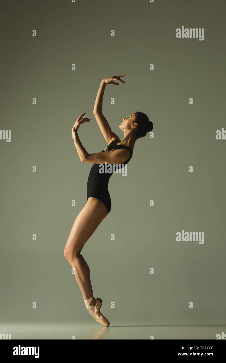 Graceful ballet dancer or classic ballerina dancing isolated on grey ...
