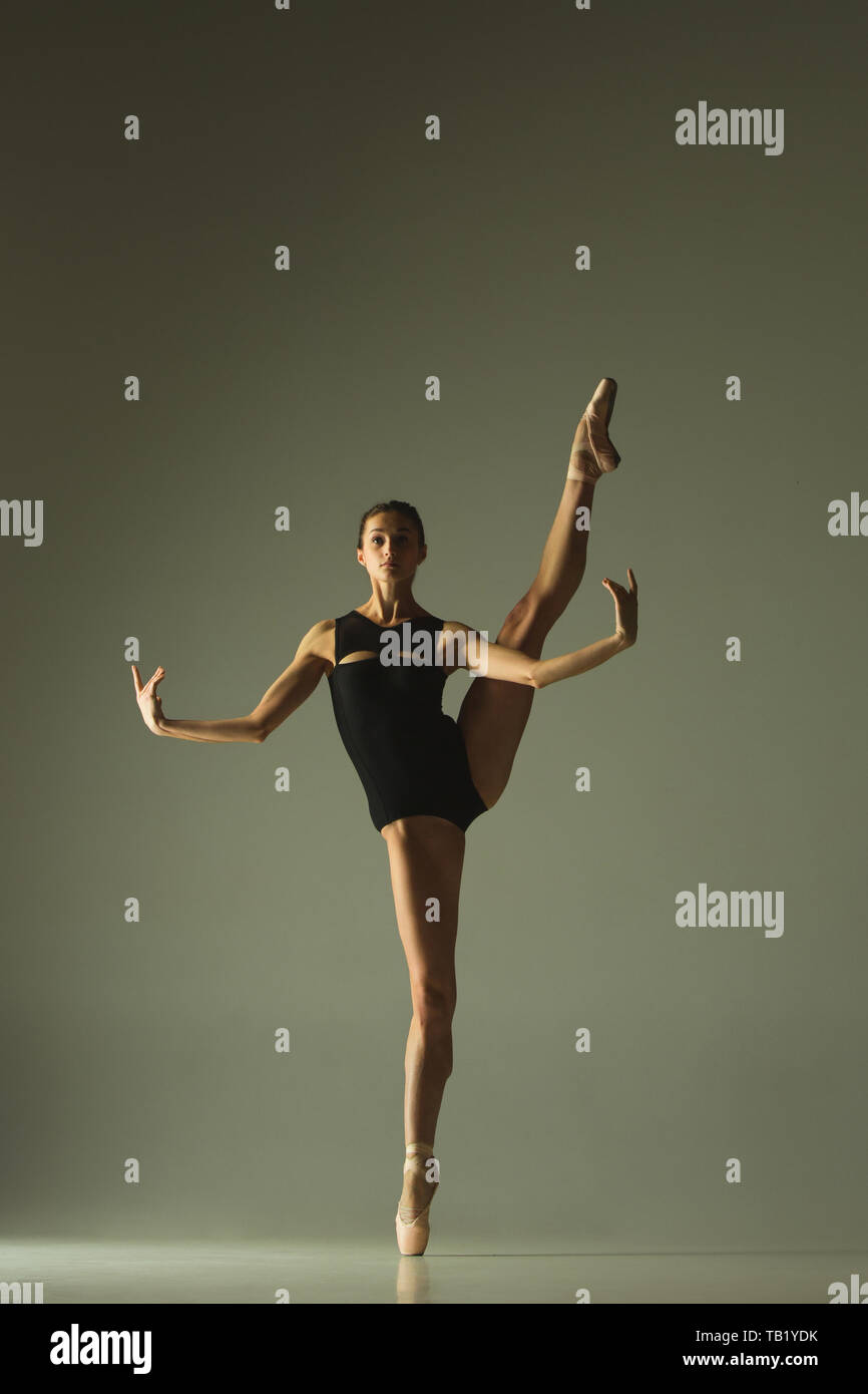Graceful ballet dancer or classic ballerina dancing isolated on grey ...