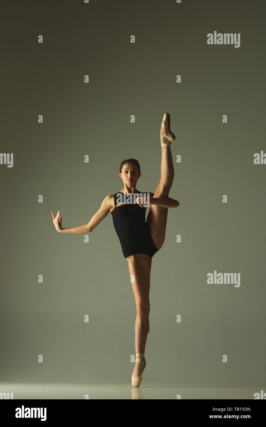 Graceful ballet dancer or classic ballerina dancing isolated on grey ...