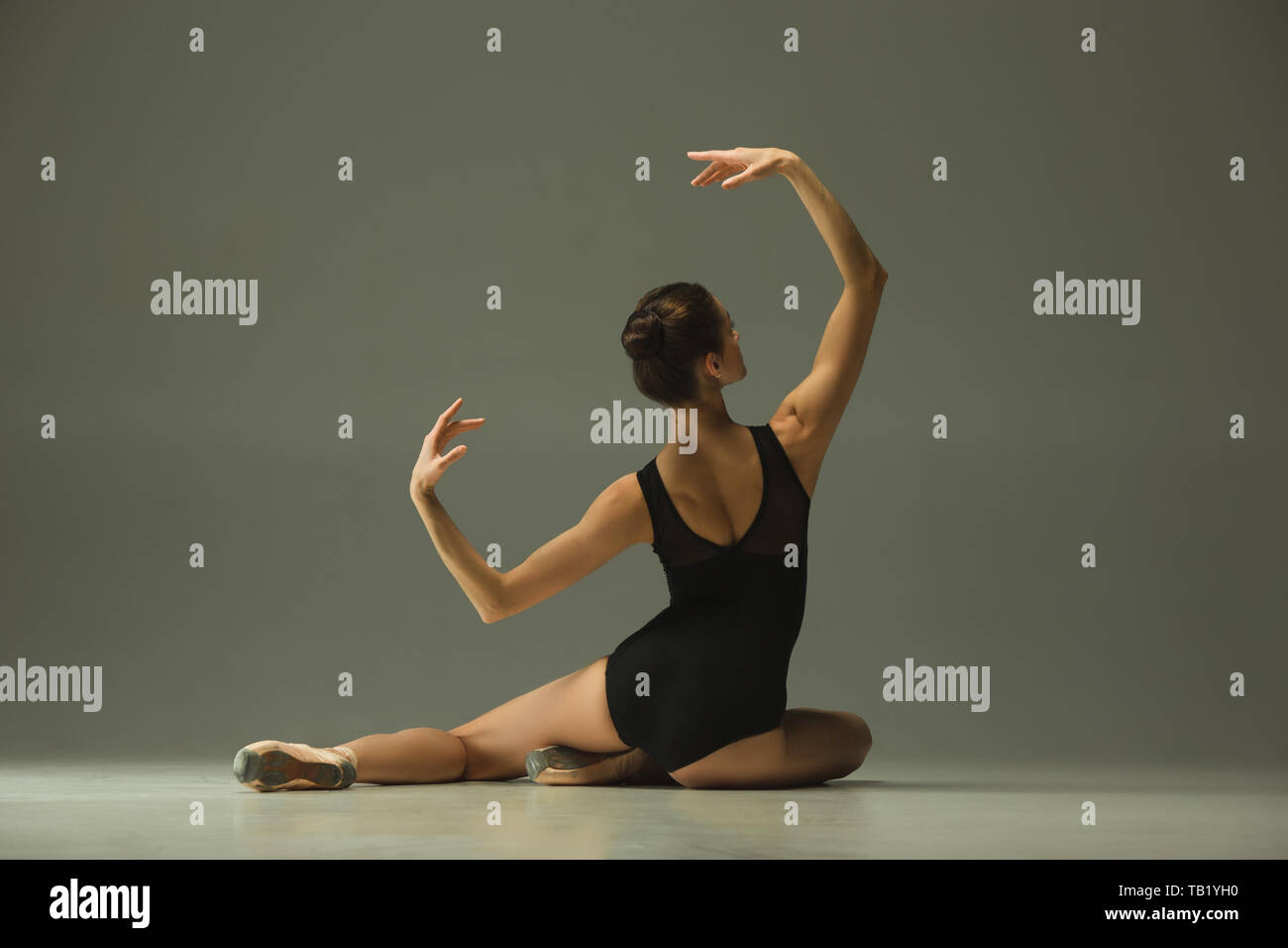 Graceful ballet dancer or classic ballerina dancing isolated on grey ...