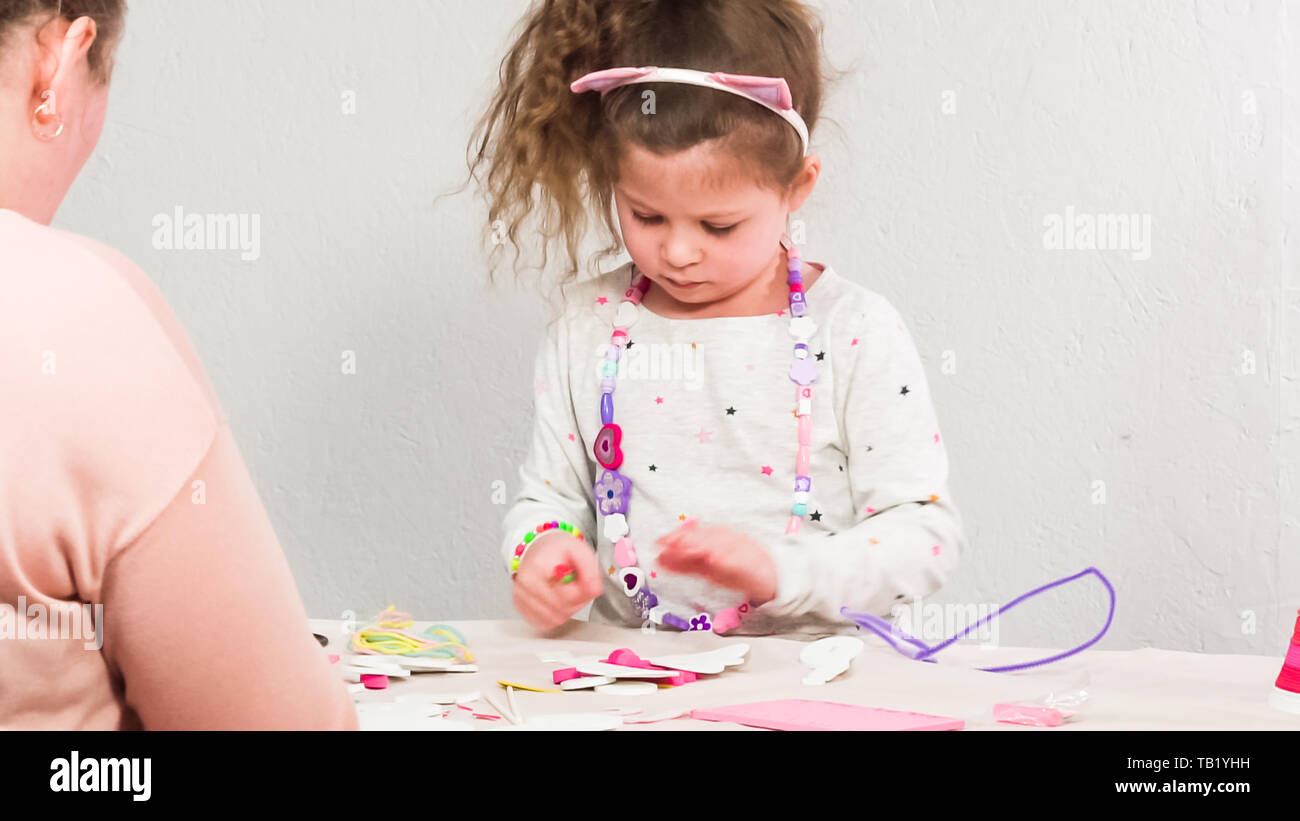 Step by step. Mother and daughter making unicorn craft from paper foam ...