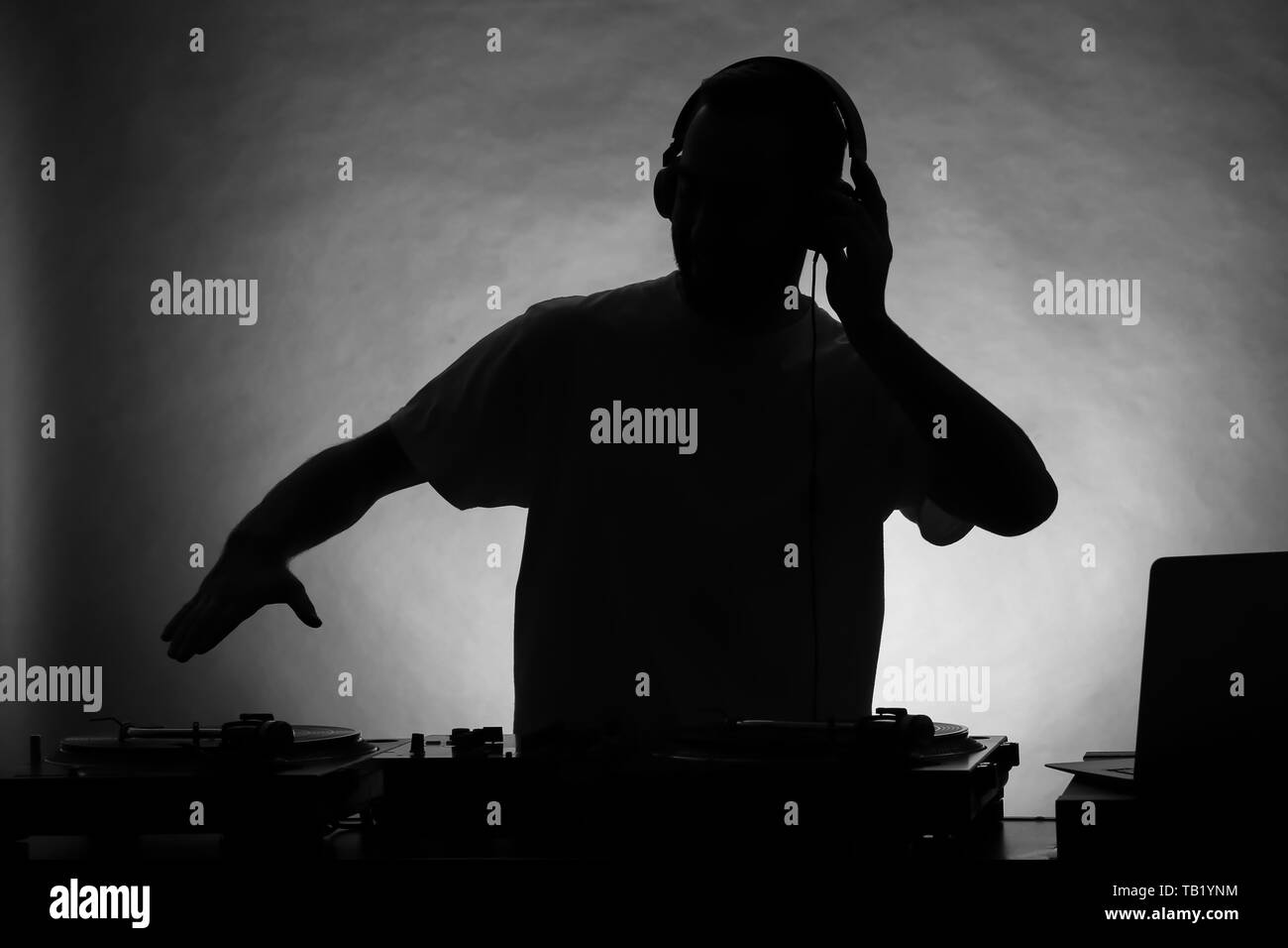 Silhouette of male DJ playing music on grey background Stock Photo - Alamy