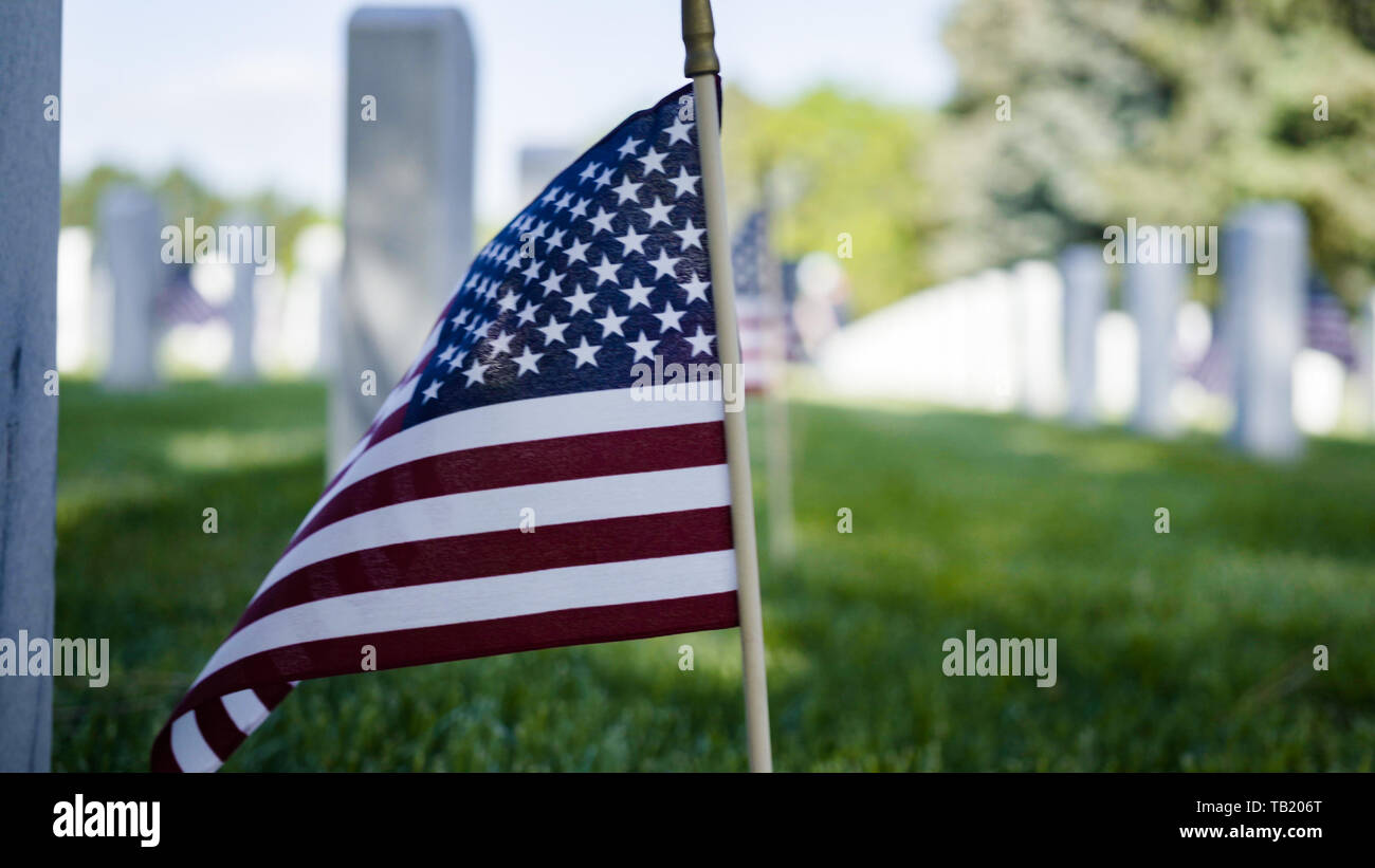 Small American Flags next to white marble gravestones at the Fort Logan ...