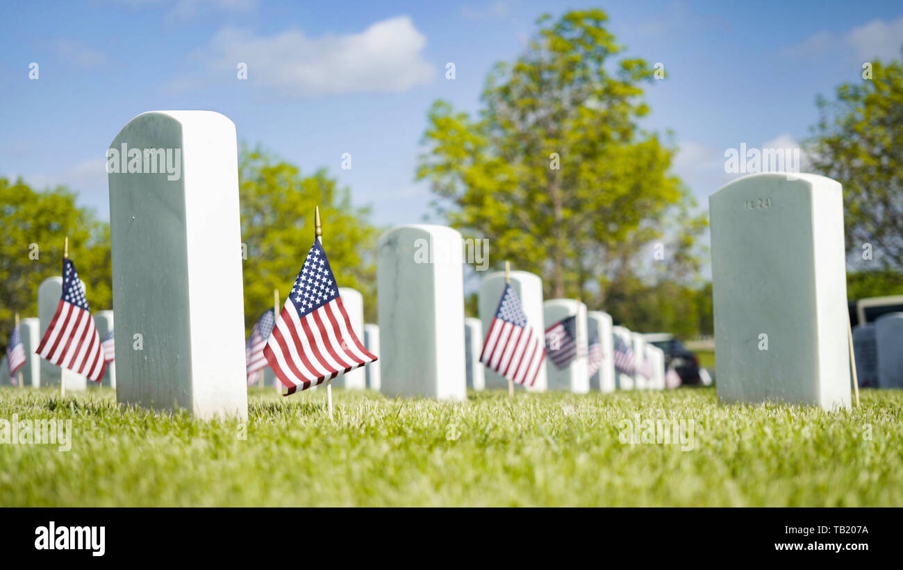 Small American Flags next to white marble gravestones at the Fort Logan ...