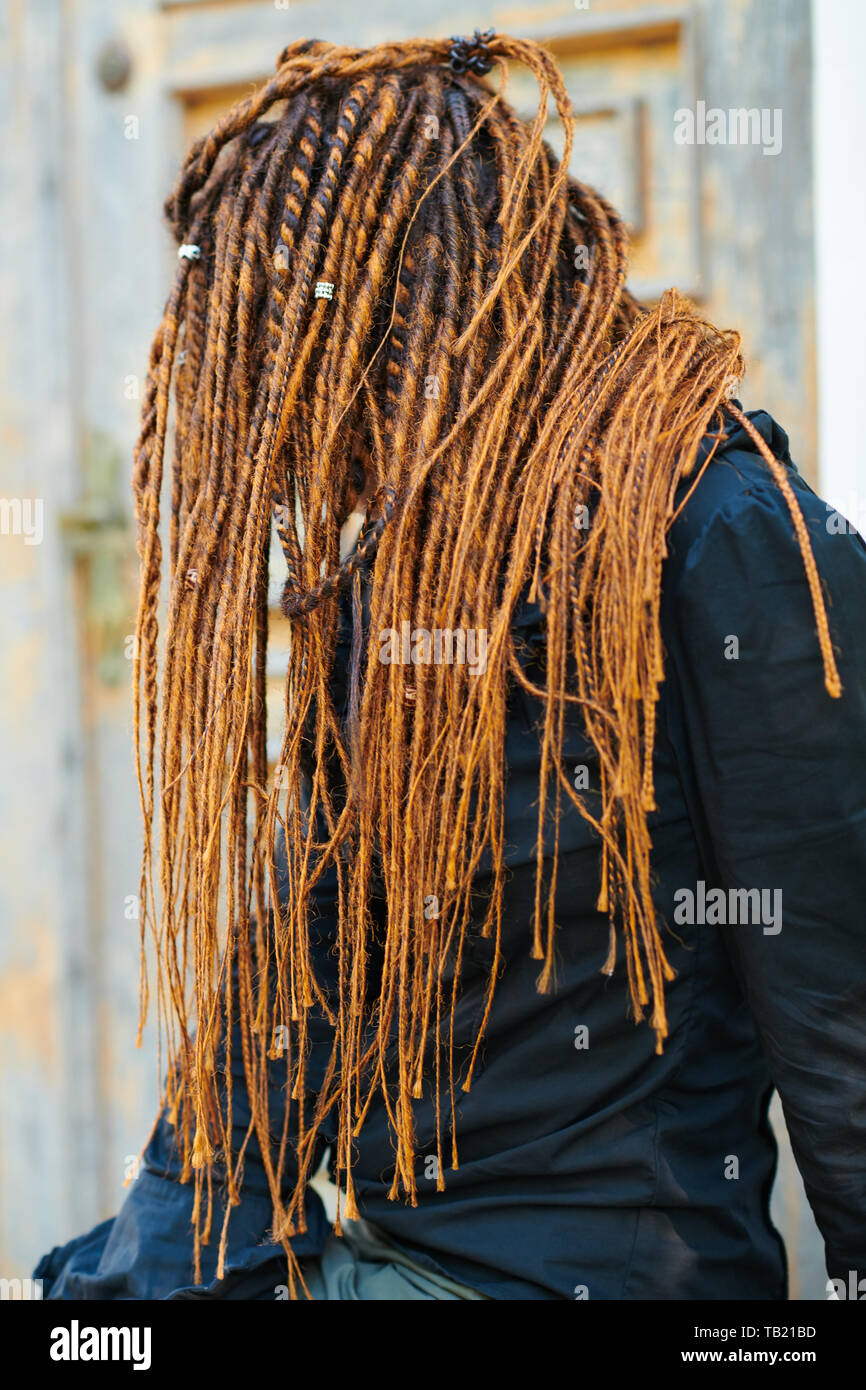 dreadlocks fashionable girl posing at old wooden door background. side ...