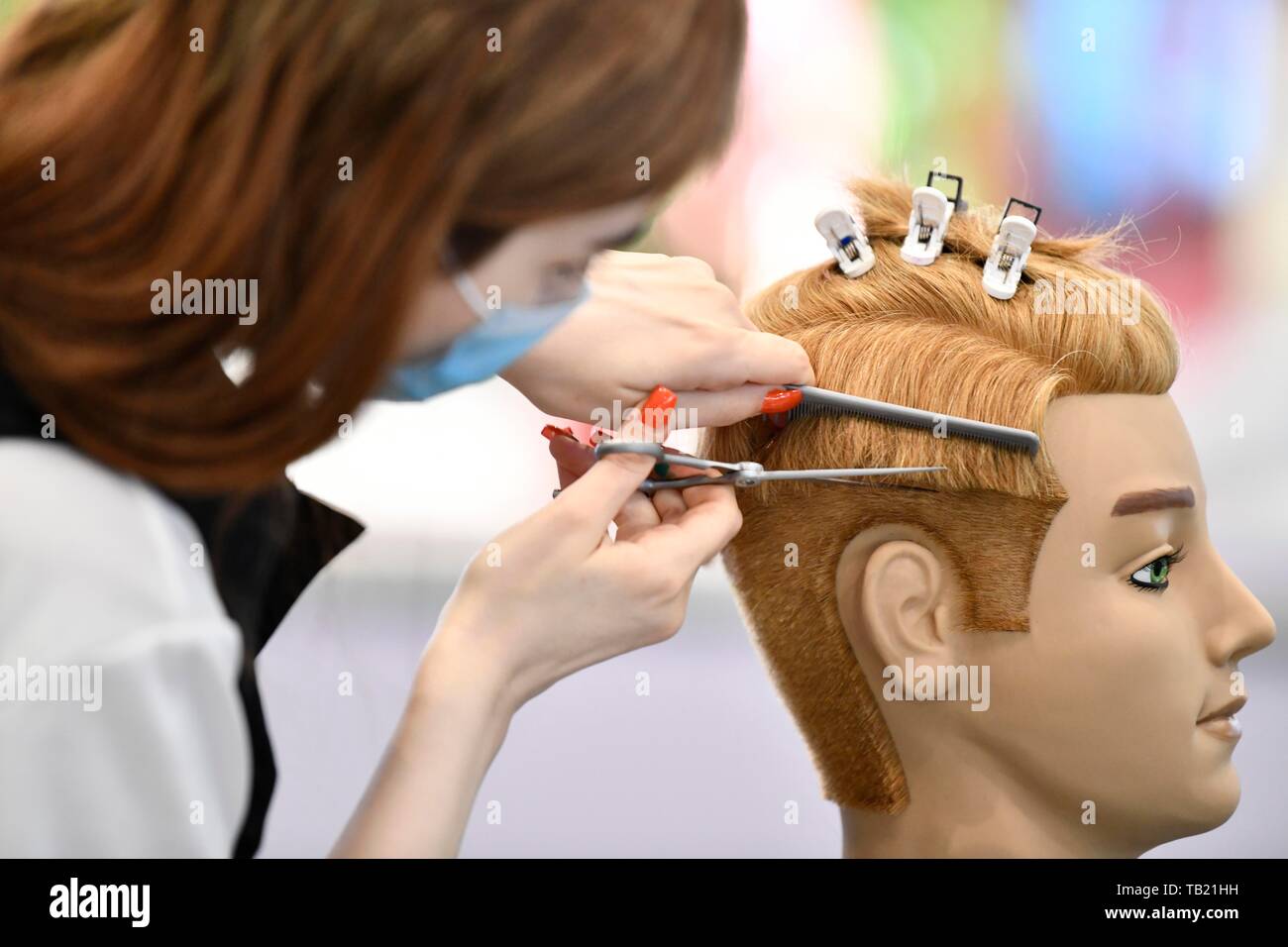 Beijing, China. 28th May, 2019. A woman participates in the haircutting ...