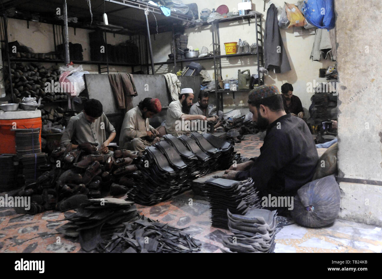 Peshawar, Pakistan. 29th May, 2019. Workers make traditional shoes ...