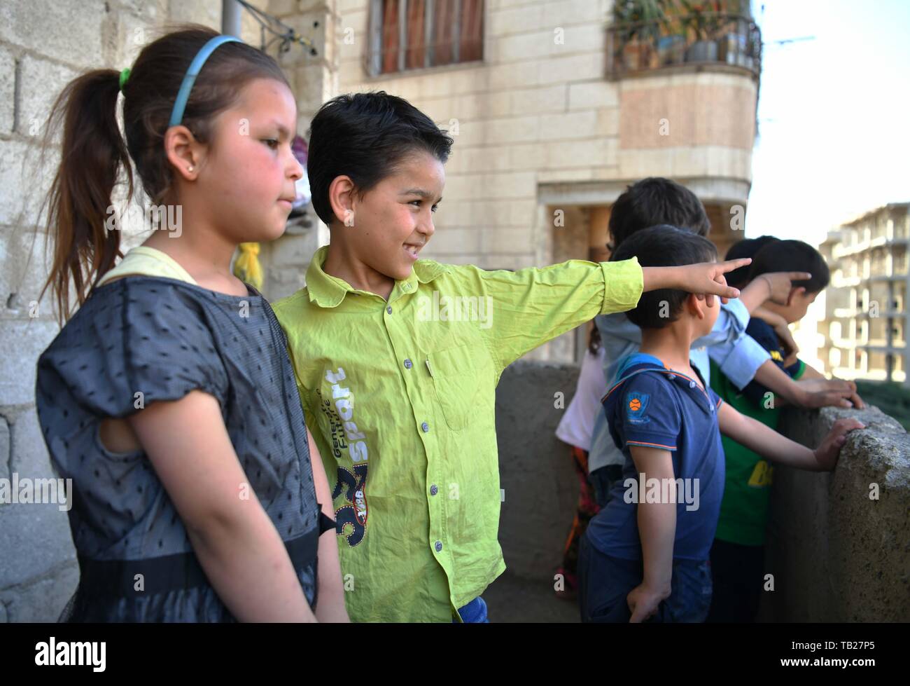 Damascus, Syria. 28th May, 2019. Ibrahim Mossa (2nd L) plays with his ...