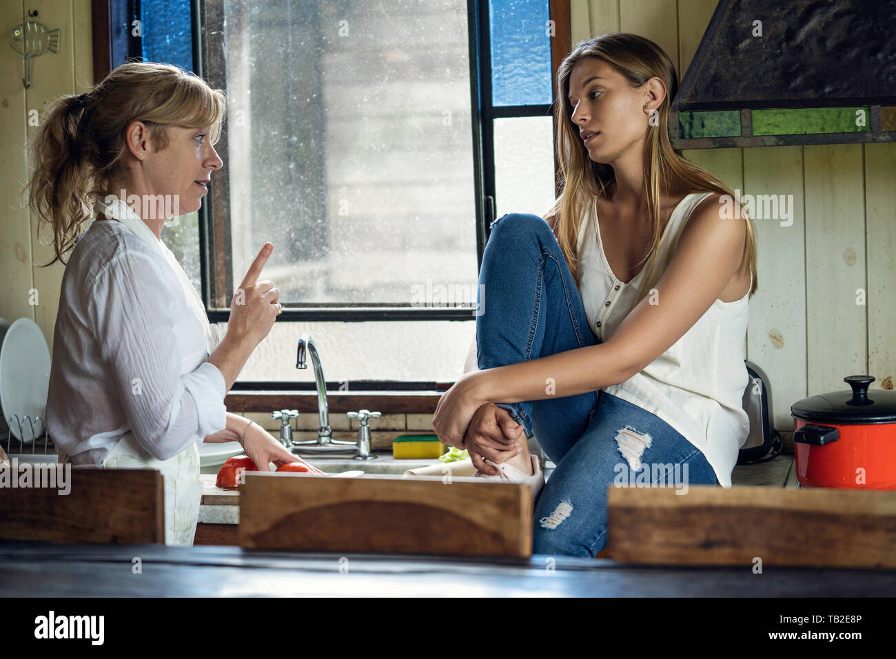 Mother and daughter talking in kitchen Stock Photo - Alamy