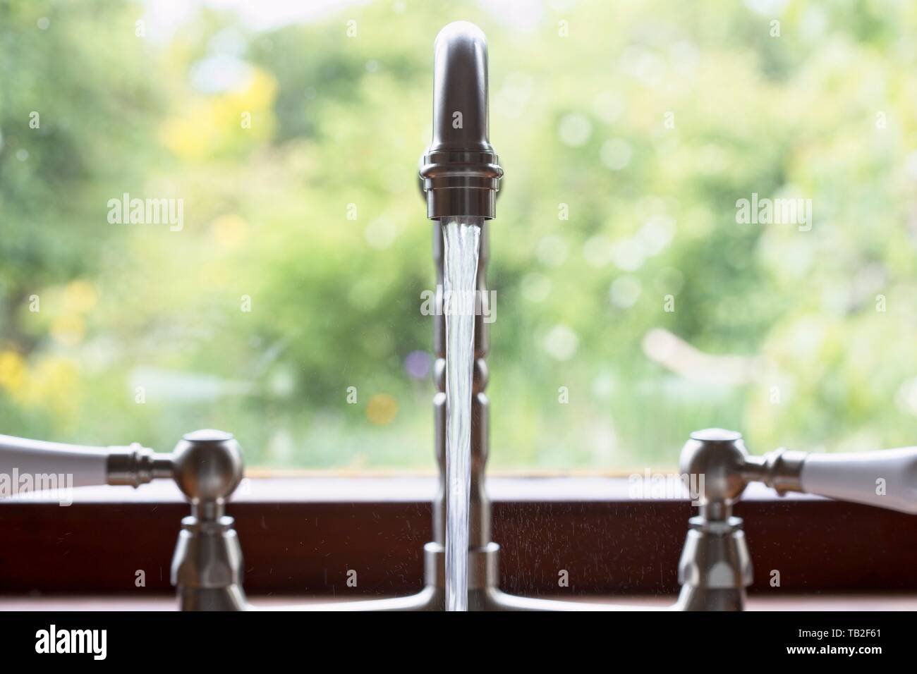Kitchen taps left running and wasting water. Uk Stock Photo - Alamy