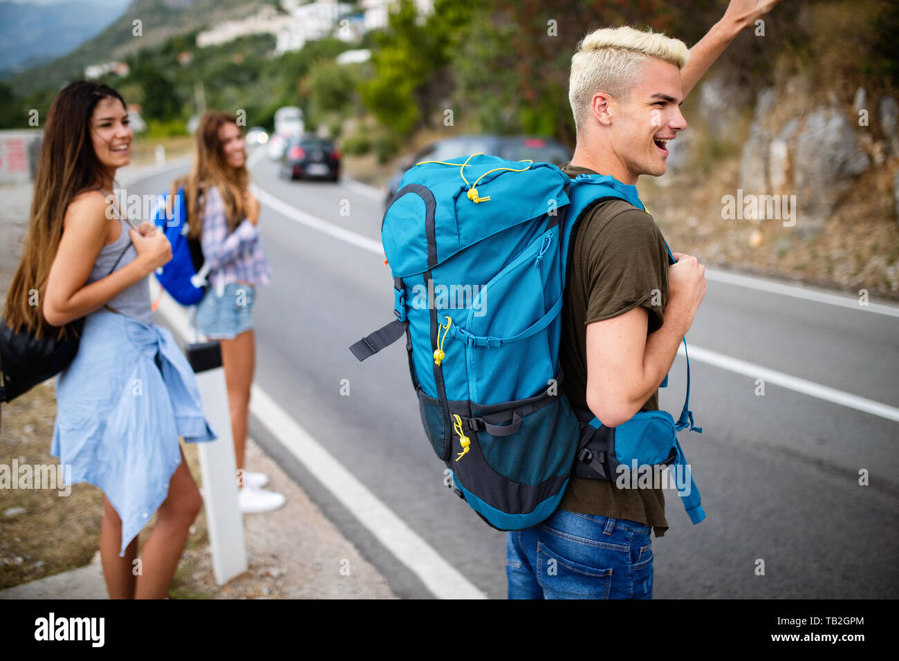 Group of young people with backpacks walking together by the road Stock ...