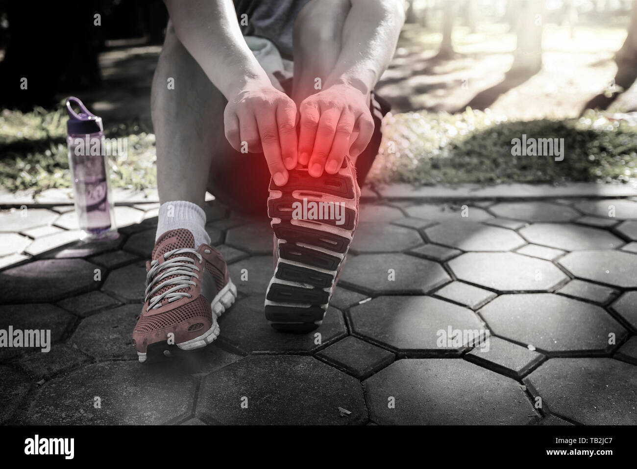 Athlete runner holding his foot in pain. He suffering from foot injury ...