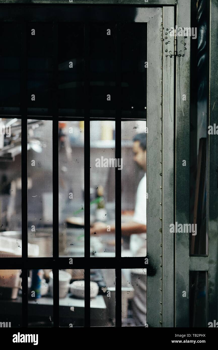 Chef working in the kitchen behind the fenced door Stock Photo - Alamy
