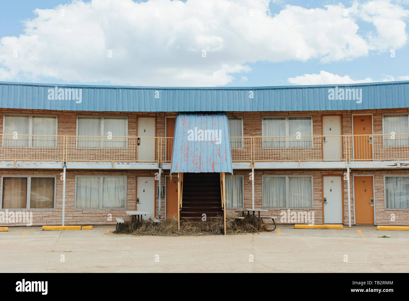 Abandoned motel building with a rusty metal awning, drawn curtains at ...