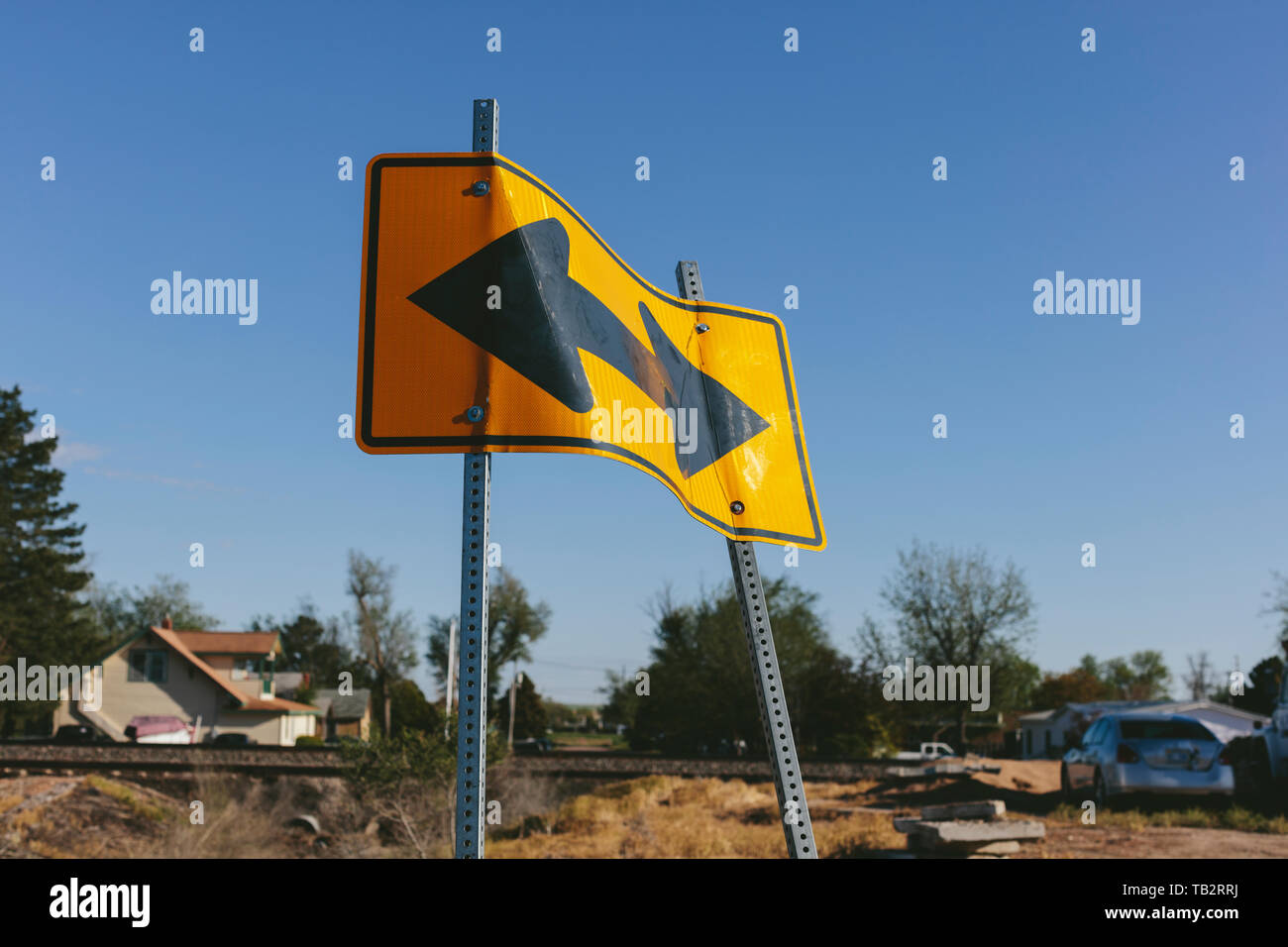 A bent old two arrow road side, arrows pointing in two different ...