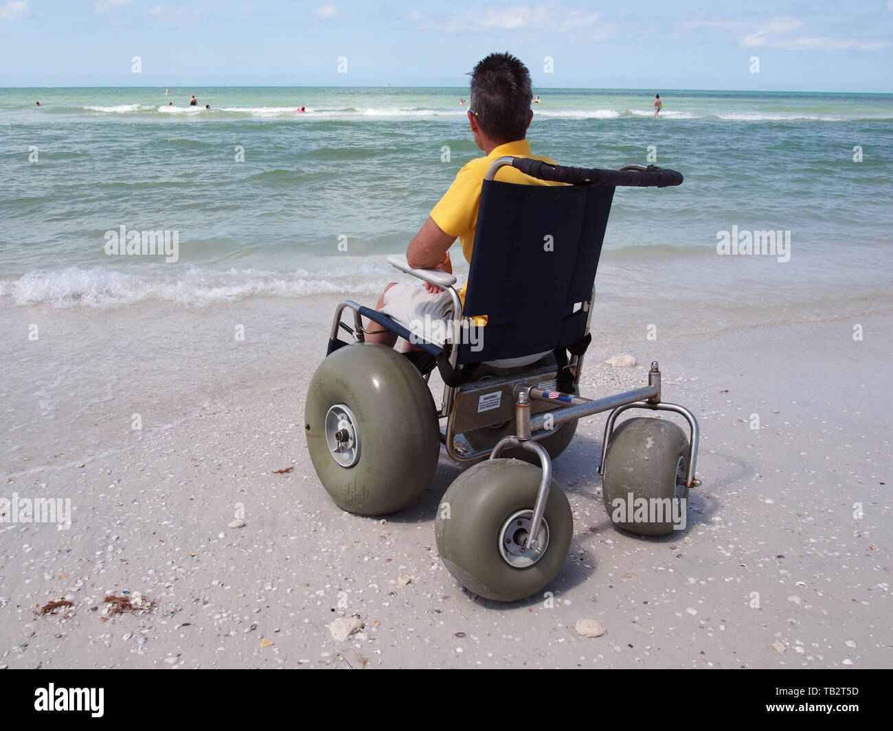 Disabled woman in beach wheelchair enjoys the sun and sand at Honeymoon ...