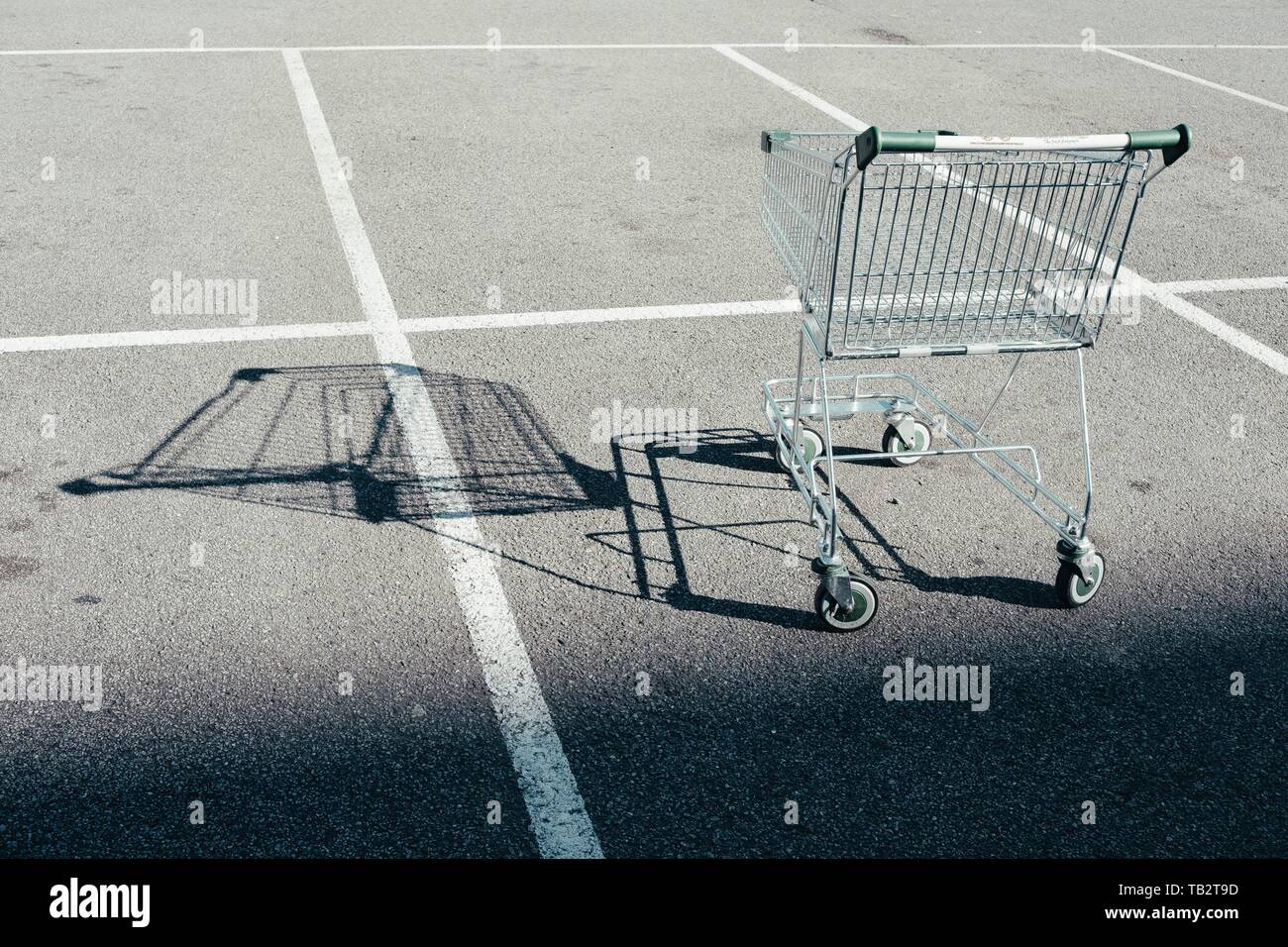 Single shopping cart in the parking lot Stock Photo - Alamy