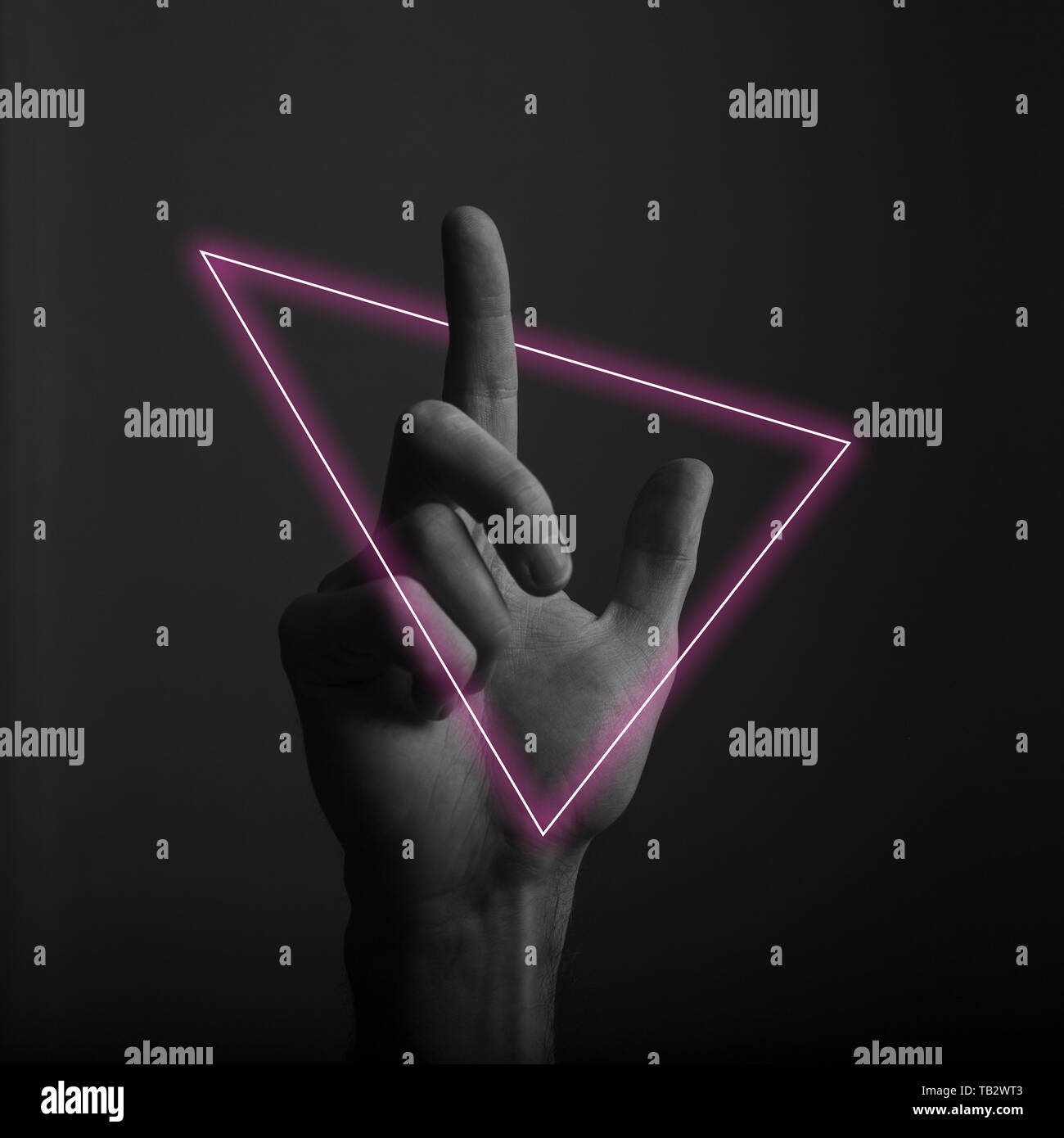 Hand pointing a finger against a dark background with abstract neon ...