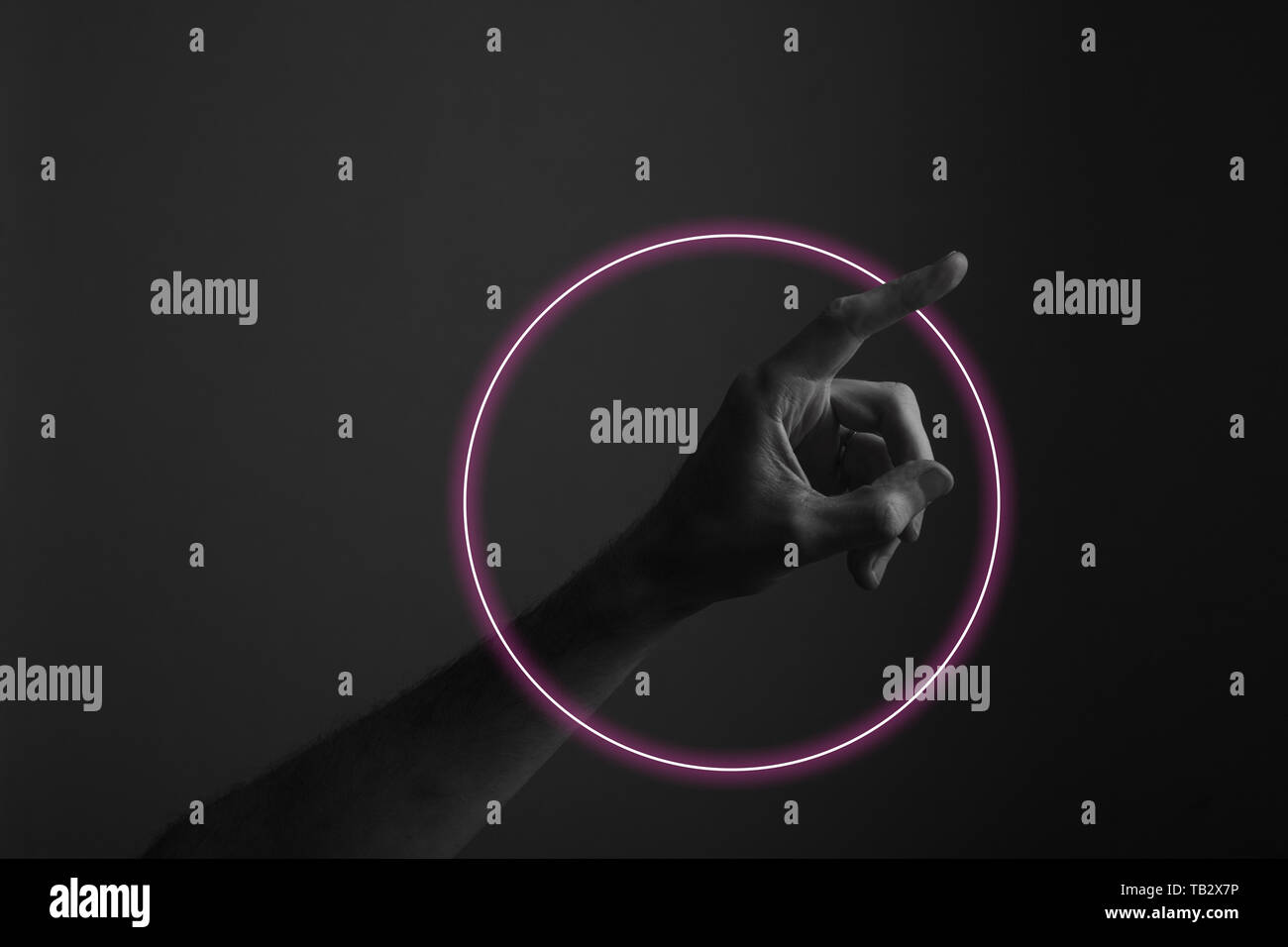 Hand pointing a finger against a dark background with abstract neon ...