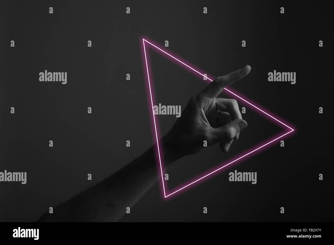 Hand pointing a finger against a dark background with abstract neon ...