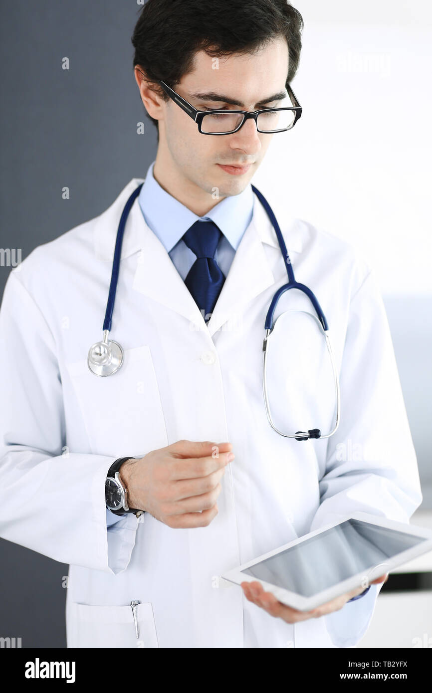 Doctor man using tablet computer for network research or virtual ...