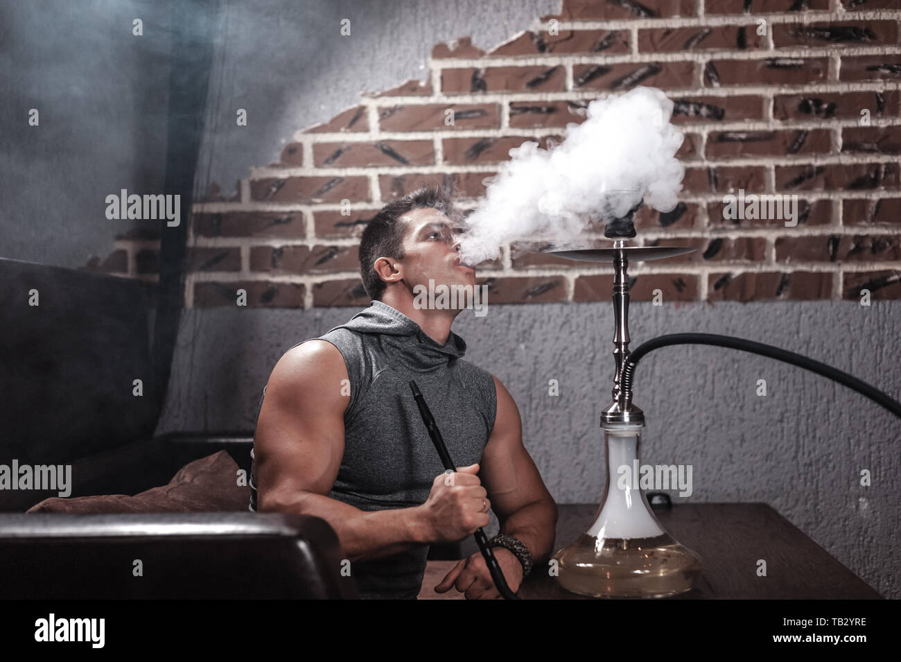 Young handsome man in the hookah room in the shisha bar Stock Photo - Alamy