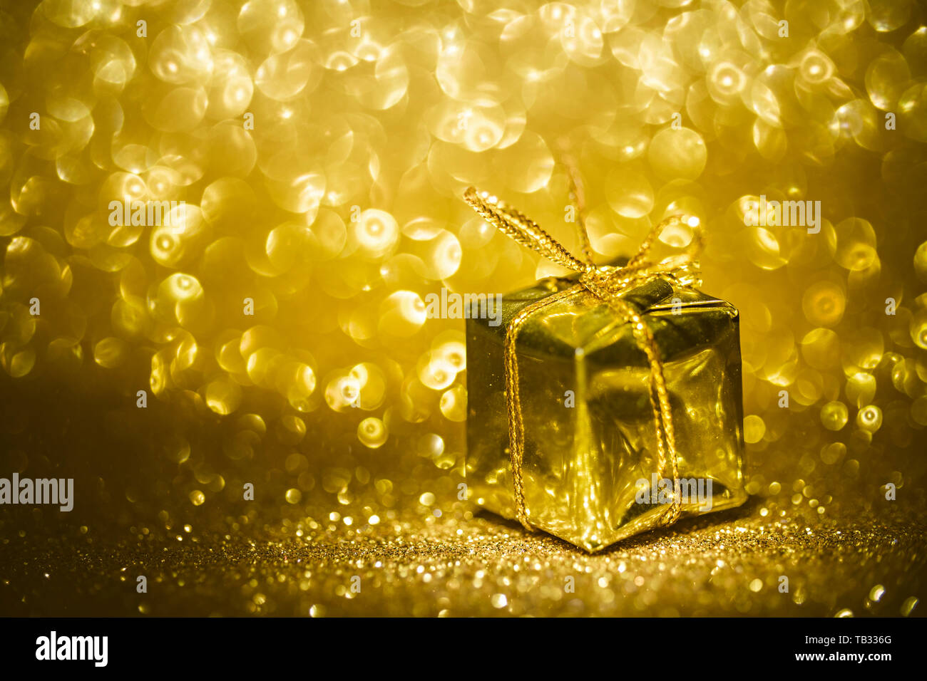 Golden metallic gift pack on glittery golden background Stock Photo - Alamy