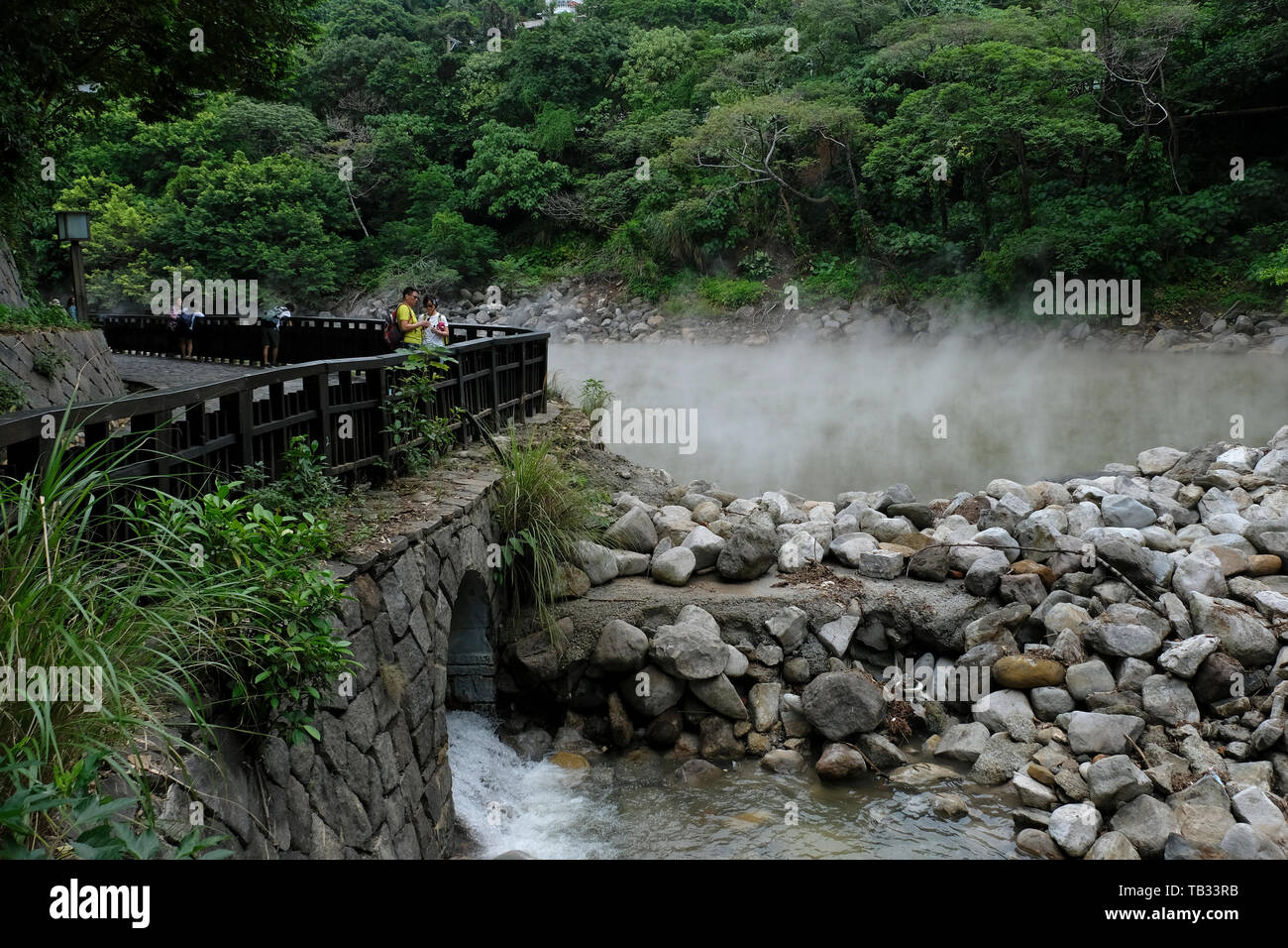 Clouds of sulfuric steam rising up from pool of scalding sulfur hot ...