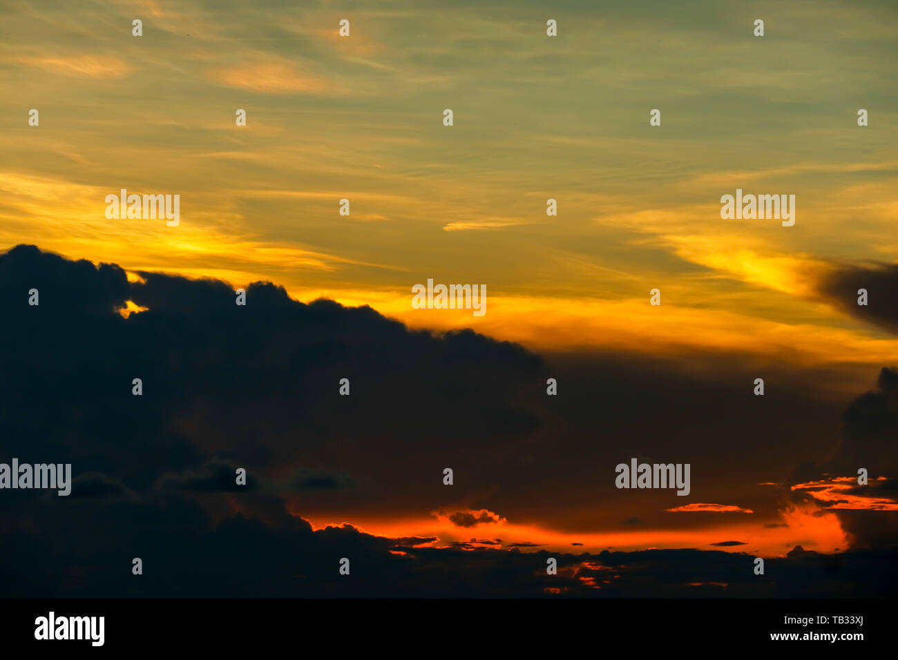 sunset sky back on dark silhouette cloud and red flame hole of sun ray ...