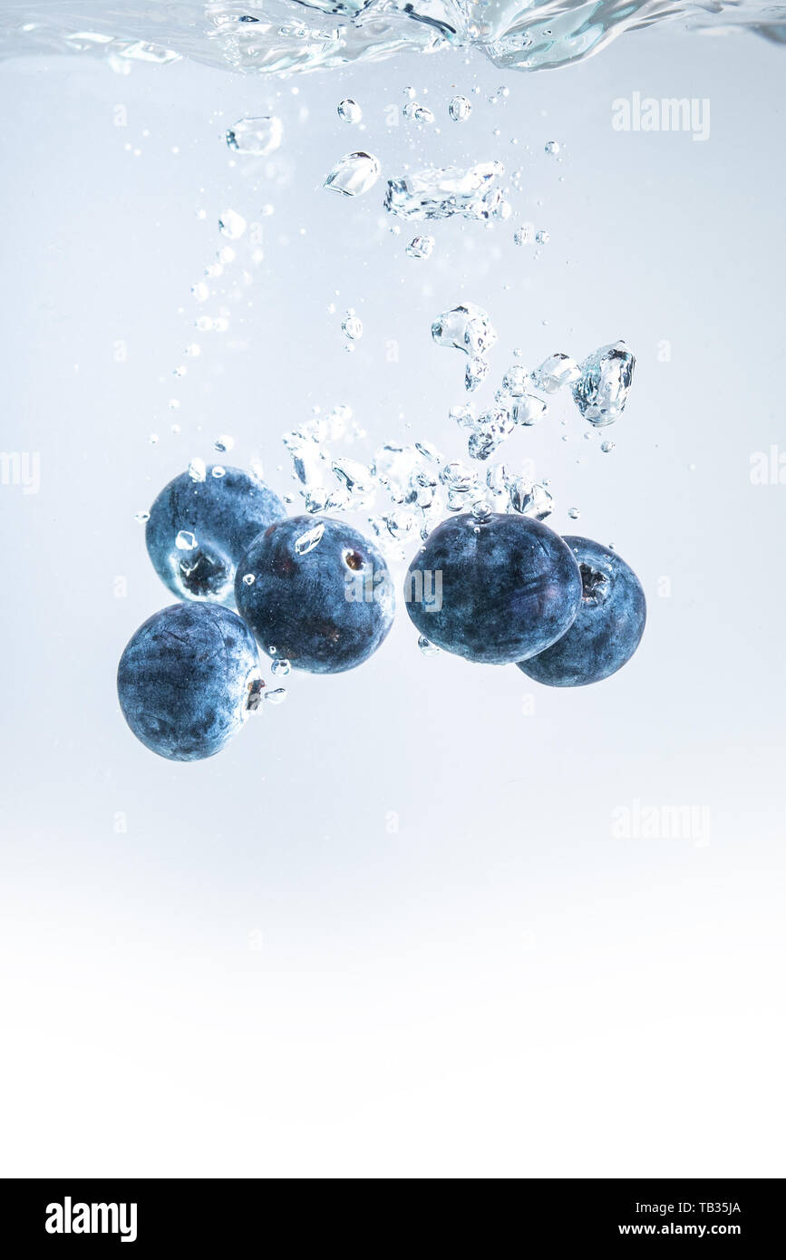 Organic Blueberries sinking into water with air bubbles white ...