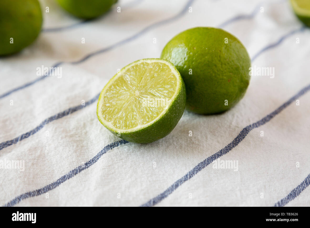 Whole and cut green citrus limes on cloth, side view. Closeup Stock ...