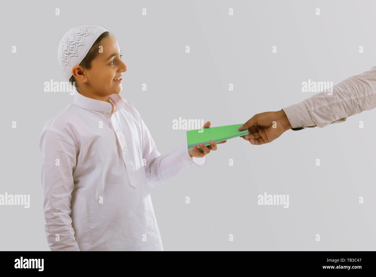 young muslim boy wearing cap receiving eidi on the occasion of eid ...
