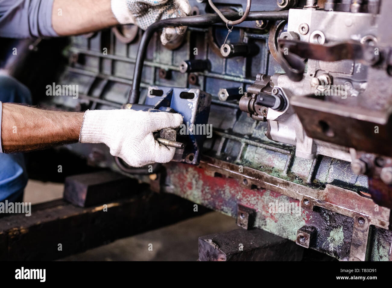 Mechanic repairs old motor of truck in a car repair station ...