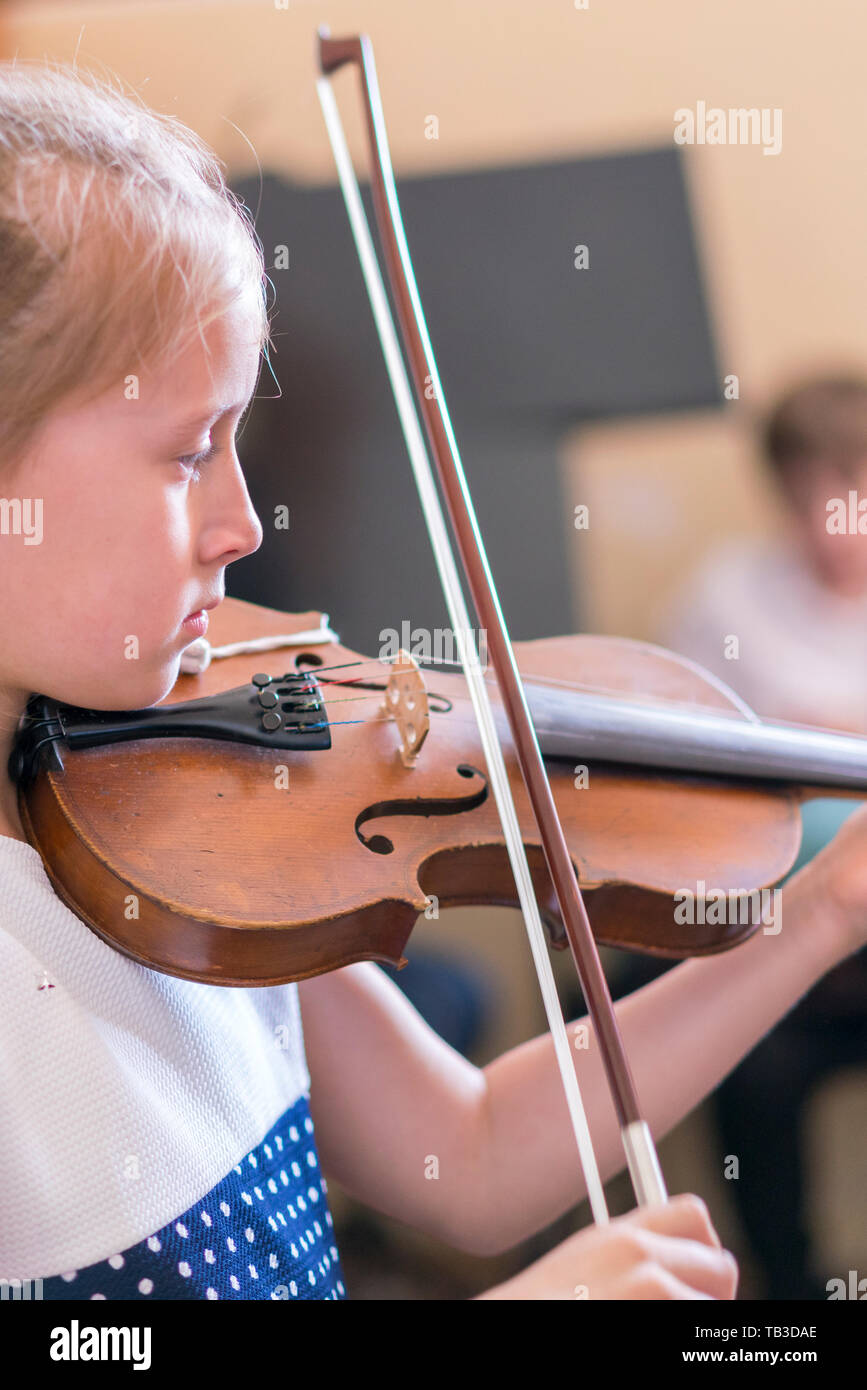 Child, little girl playing violin indoors in music class. vertical ...