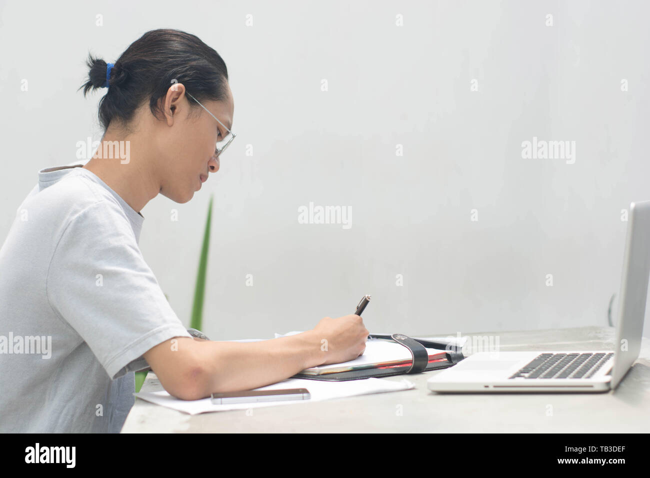 young asian student and worker, doing homework with laptop notebook ...