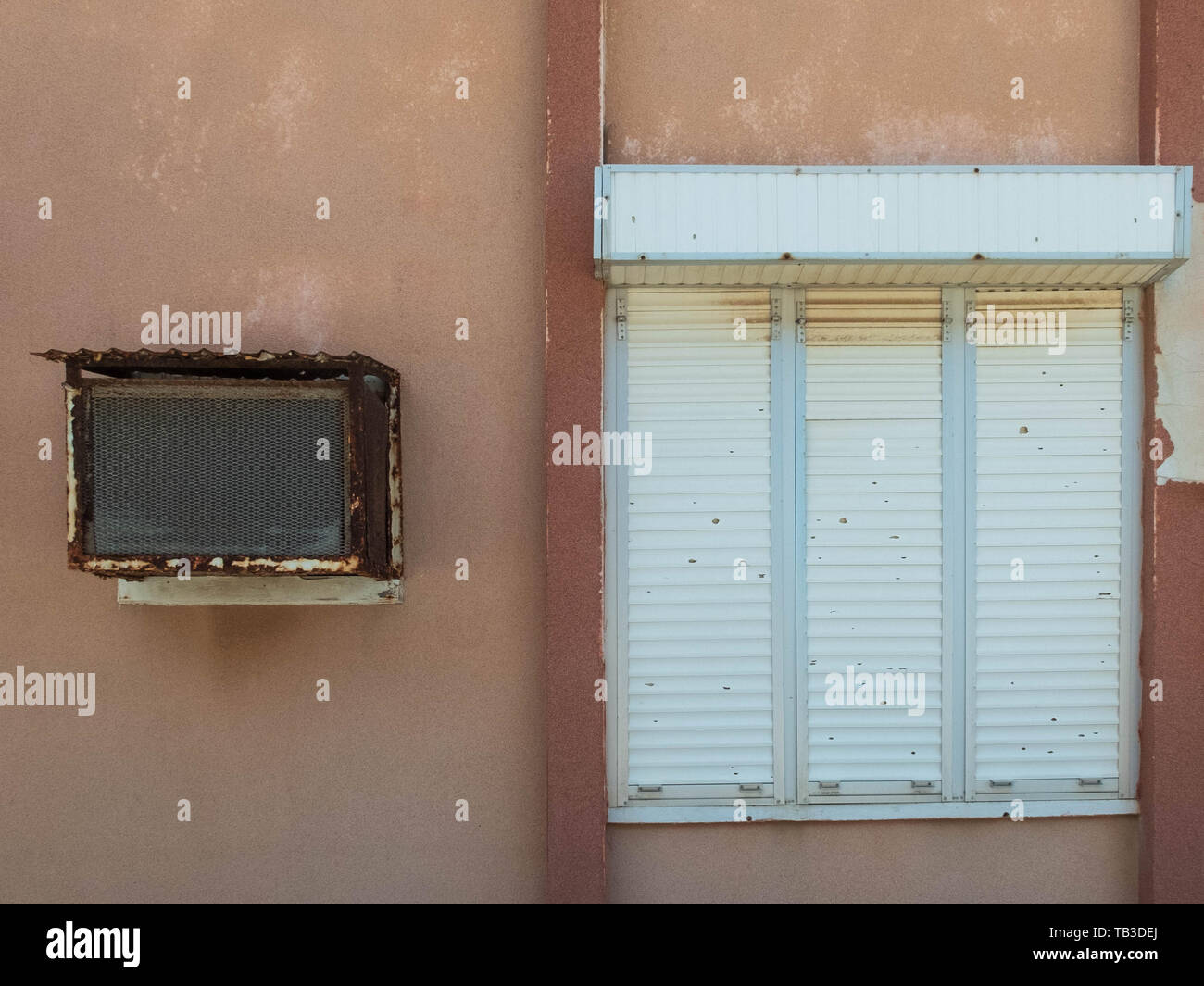Old window air conditioner and window with closed rolling shutter Stock ...